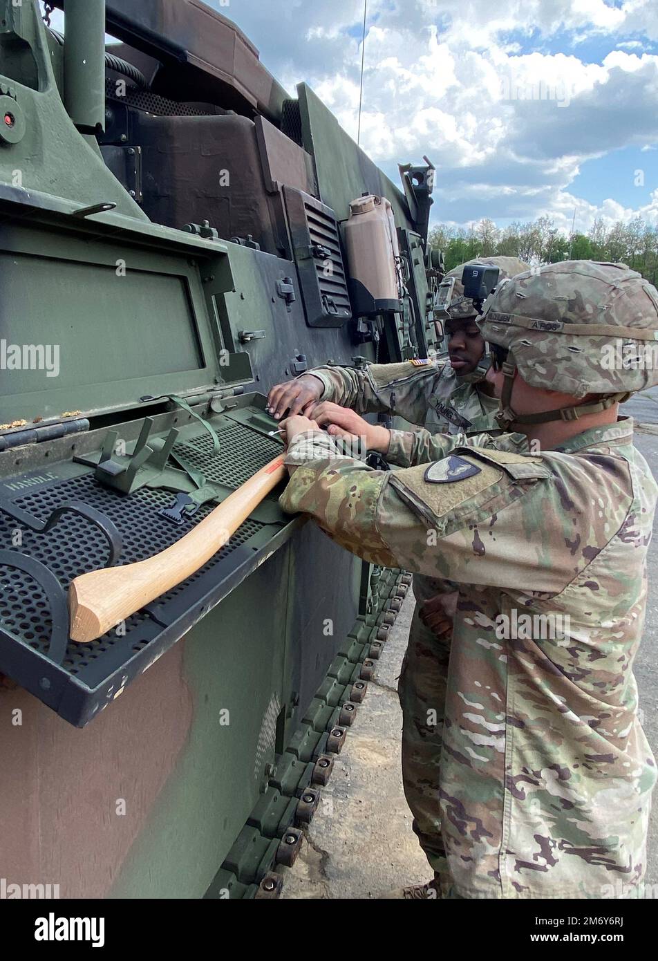 Soldiers from the 62nd Engineer Company attach an axe to an M88 ...