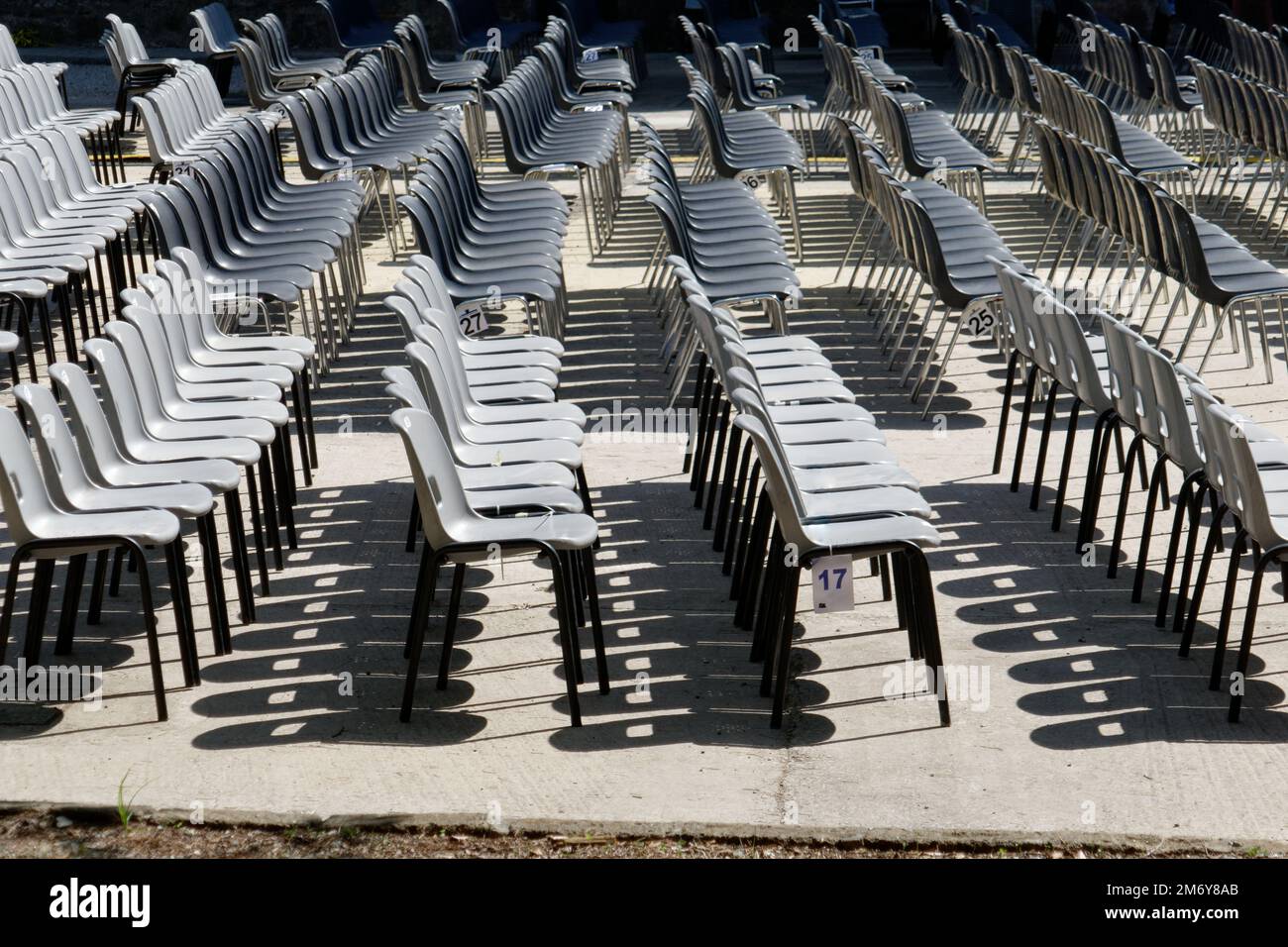 Many black and white plastic chairs were set up with the row and column ...