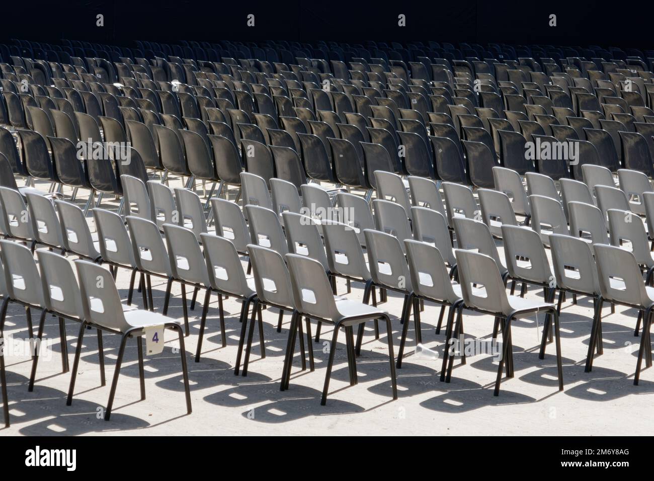 Many black and white plastic chairs were set up with the row and column ...