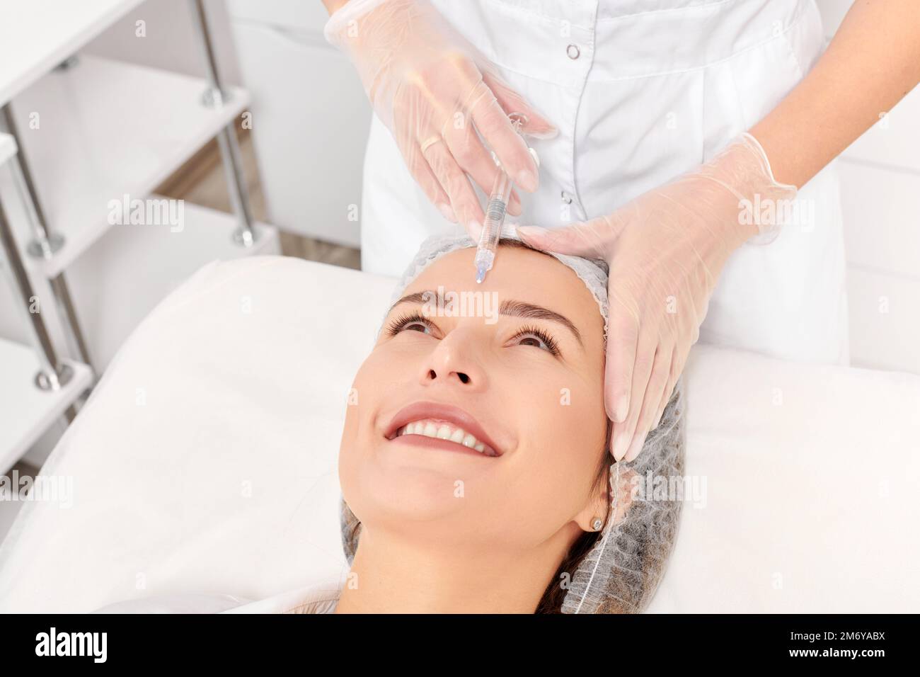 Cosmetologist makes rejuvenation injection in woman face skin, anti ...