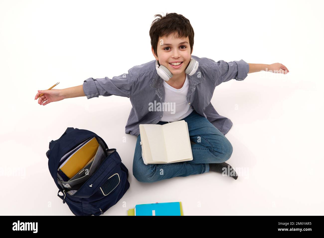 Top view handsome positive smart pupil stretching arms, smiling at ...