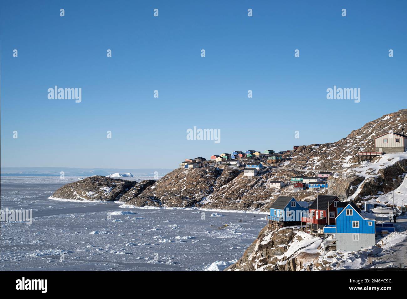 Colourful houses clinging to the side of the mountain on Uummannaq ...