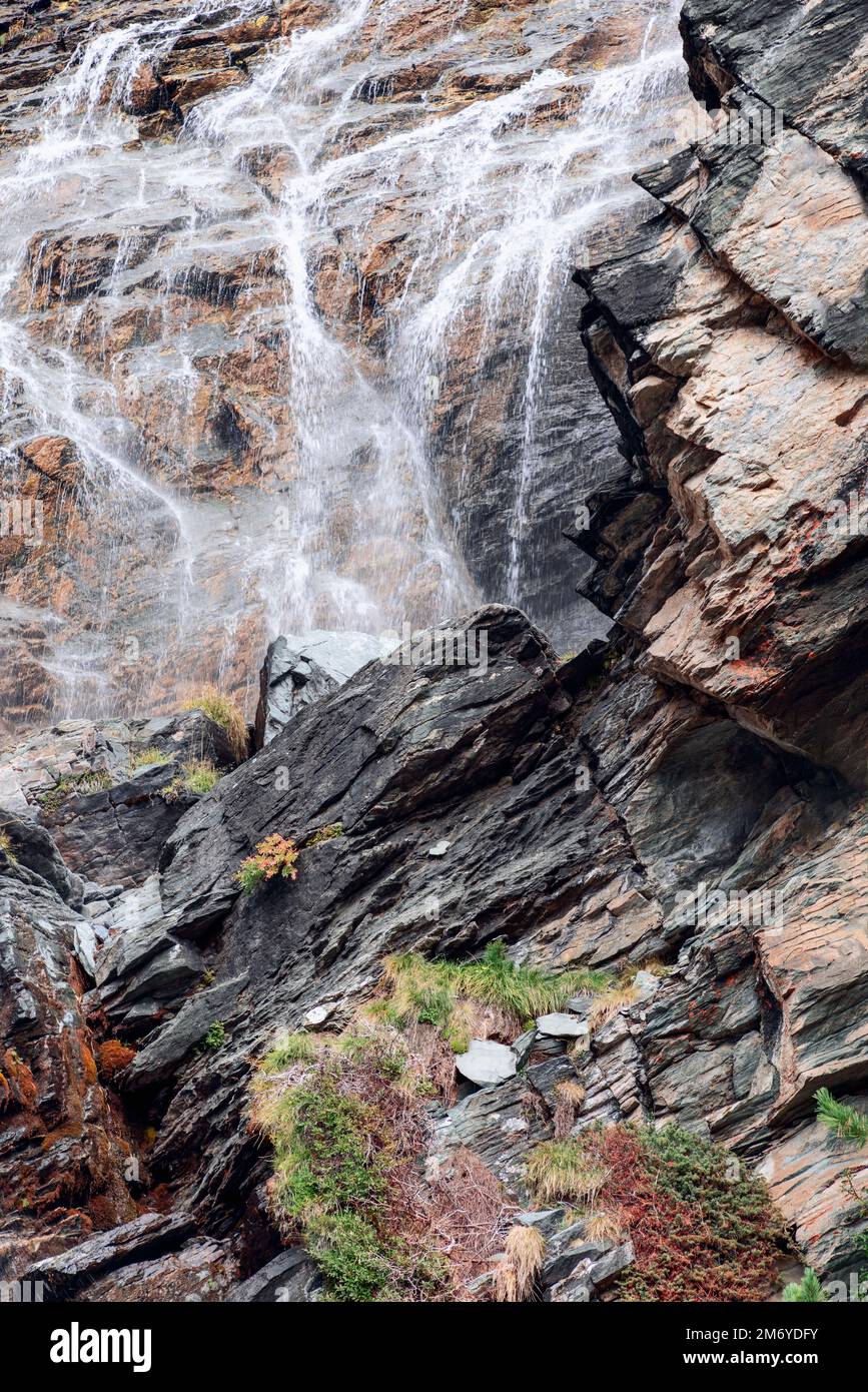 Alpine flowing waterfall washes various color karst overlays of granite ...