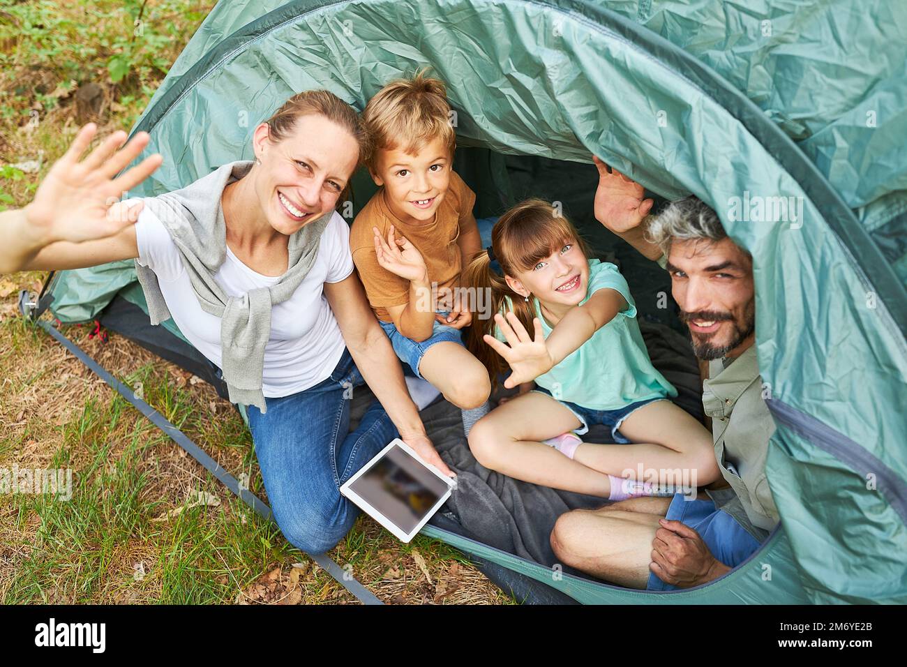 High angle portrait of cheerful family waving hands while sitting in ...