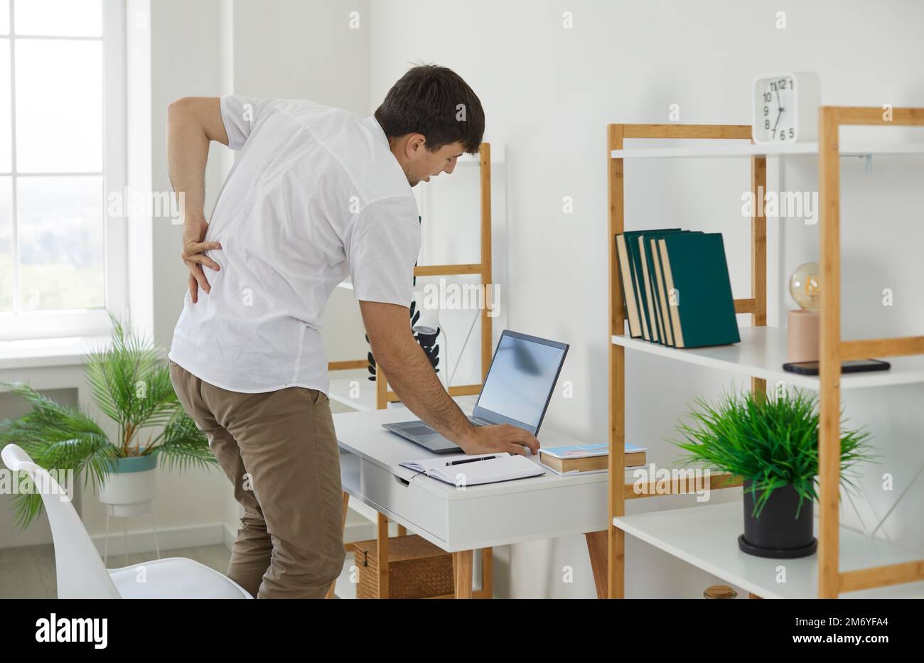 Man has sharp pain in lower back after working for long time with ...