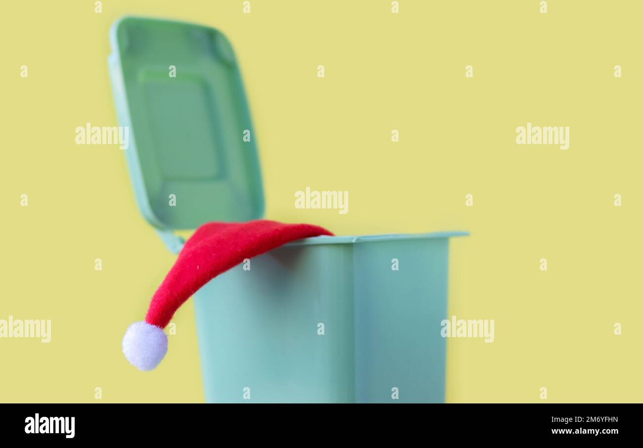 red color small lsanta cap hat throw away dropped off in mini trash bin ...