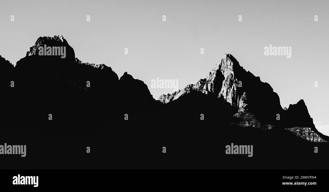 A grayscale of the tops of rocky mountains in sunlight Stock Photo - Alamy