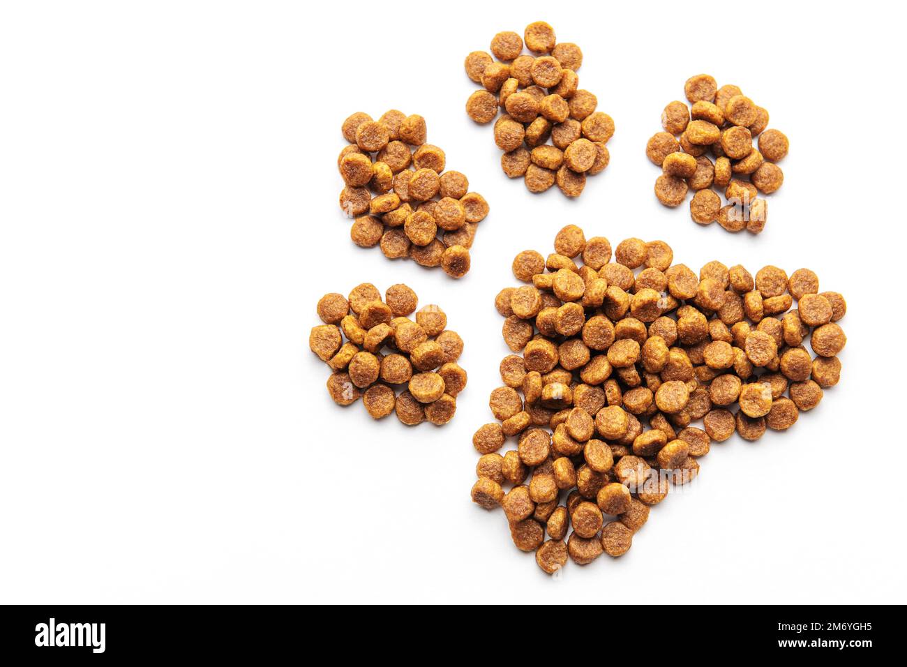 A dog's paw print consists of dog food pellets on a white background ...