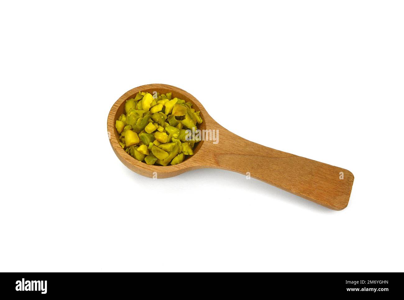 Chopped Pistachios in a wooden spoon isolated on white Background Stock ...