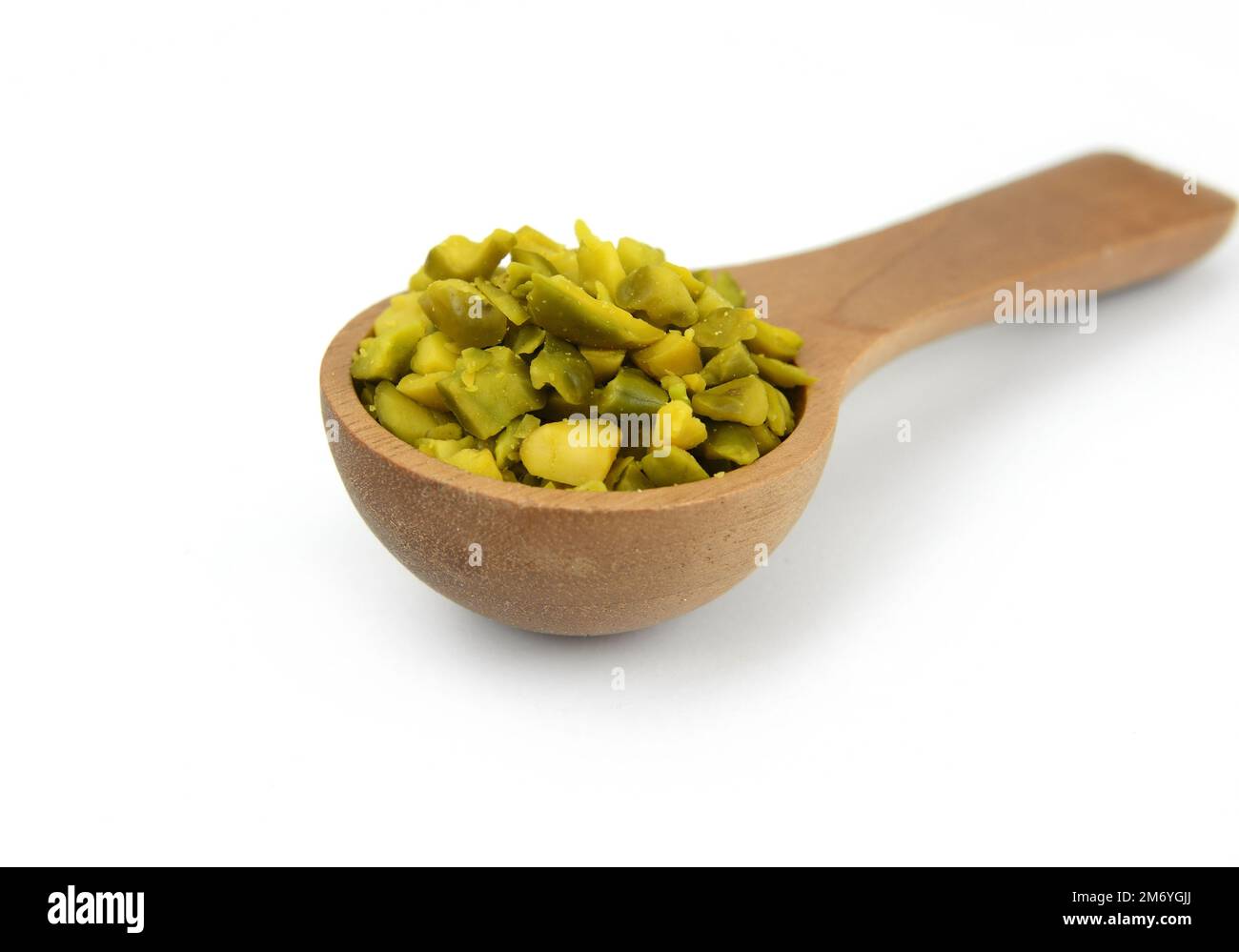Chopped Pistachios in a wooden spoon isolated on white Background Stock ...