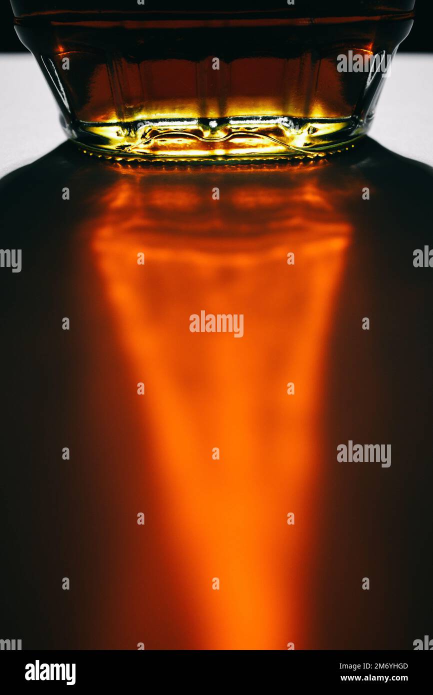 bottle of dark brown canadian maple syrup reflecting on white ...