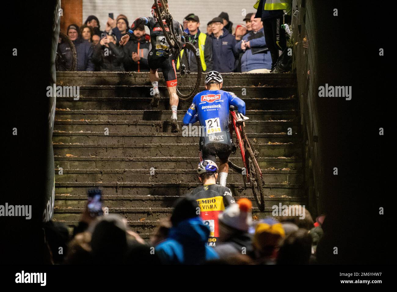 Eli Iserbyt, Mathieu van der Poel and Wout van Aert run up a flight of ...