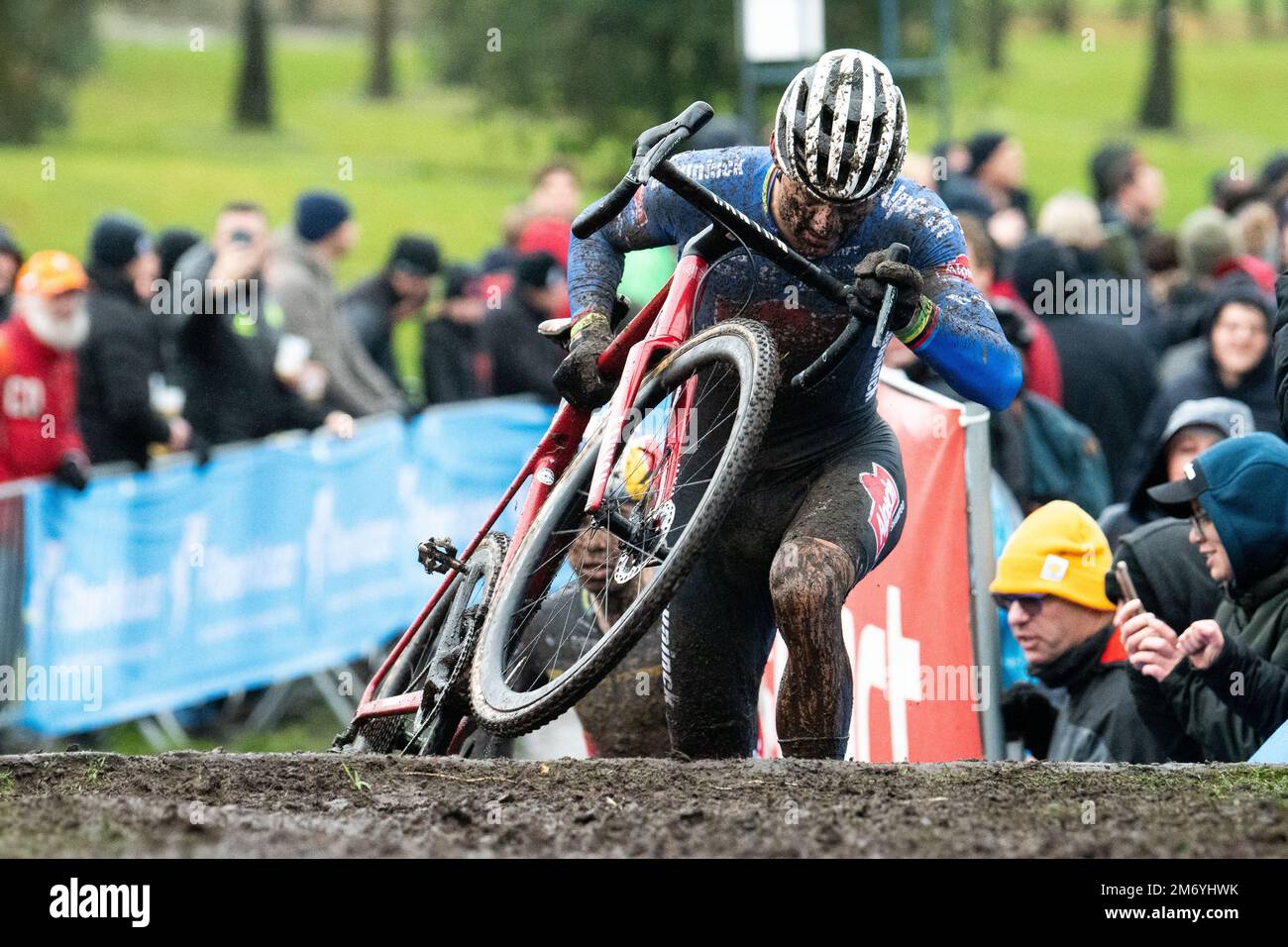 Mathieu van der Poel climbs a set of stairs carrying his bike in the ...