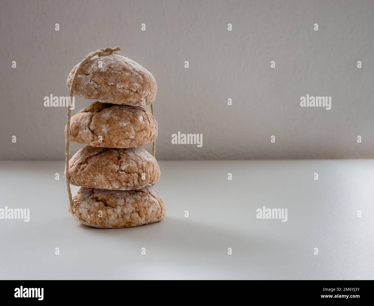 A stack of homemade hazelnut cookies tied with a string on a light ...