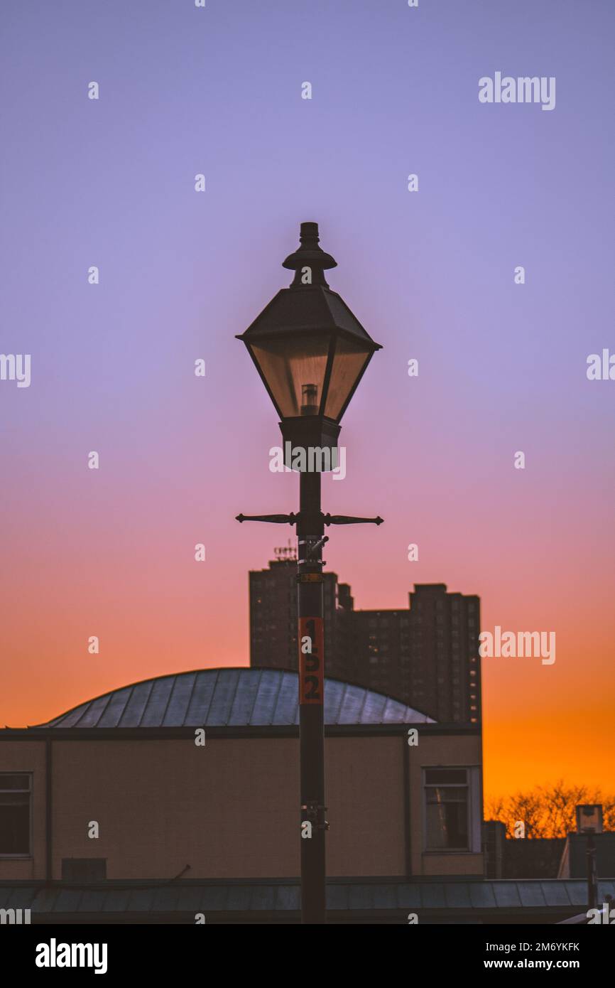 A vertical of a lamp post, street lantern captured against the sunset ...