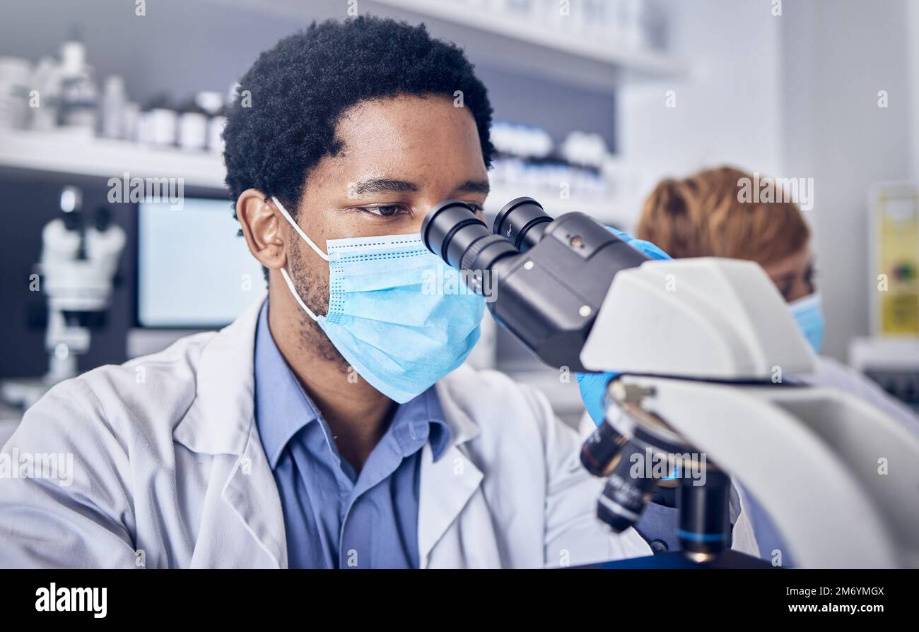 Science, covid and black man in laboratory with microscope and face ...