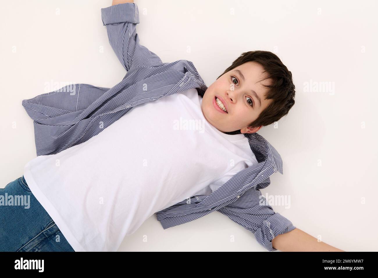 View from above of Caucasian adorable teen boy in blue jeans and white ...
