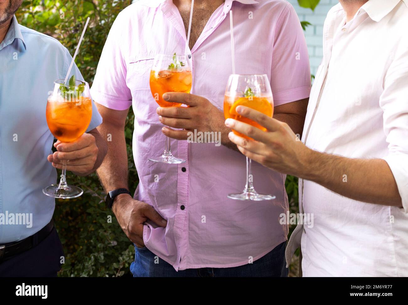 Male friends spending time together, drinking Aperol spritz cocktail on ...