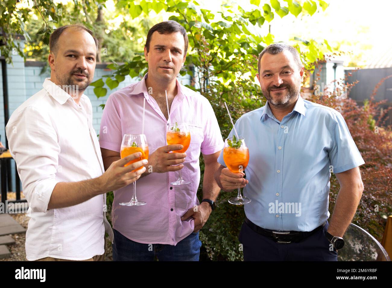 Male friends spending time together, drinking Aperol spritz cocktail on ...