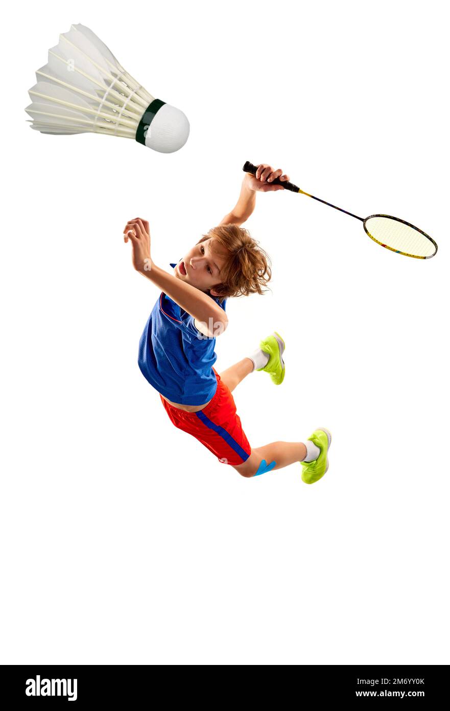Portrait of teen boy in uniform playing badminton, serving shuttlecock ...