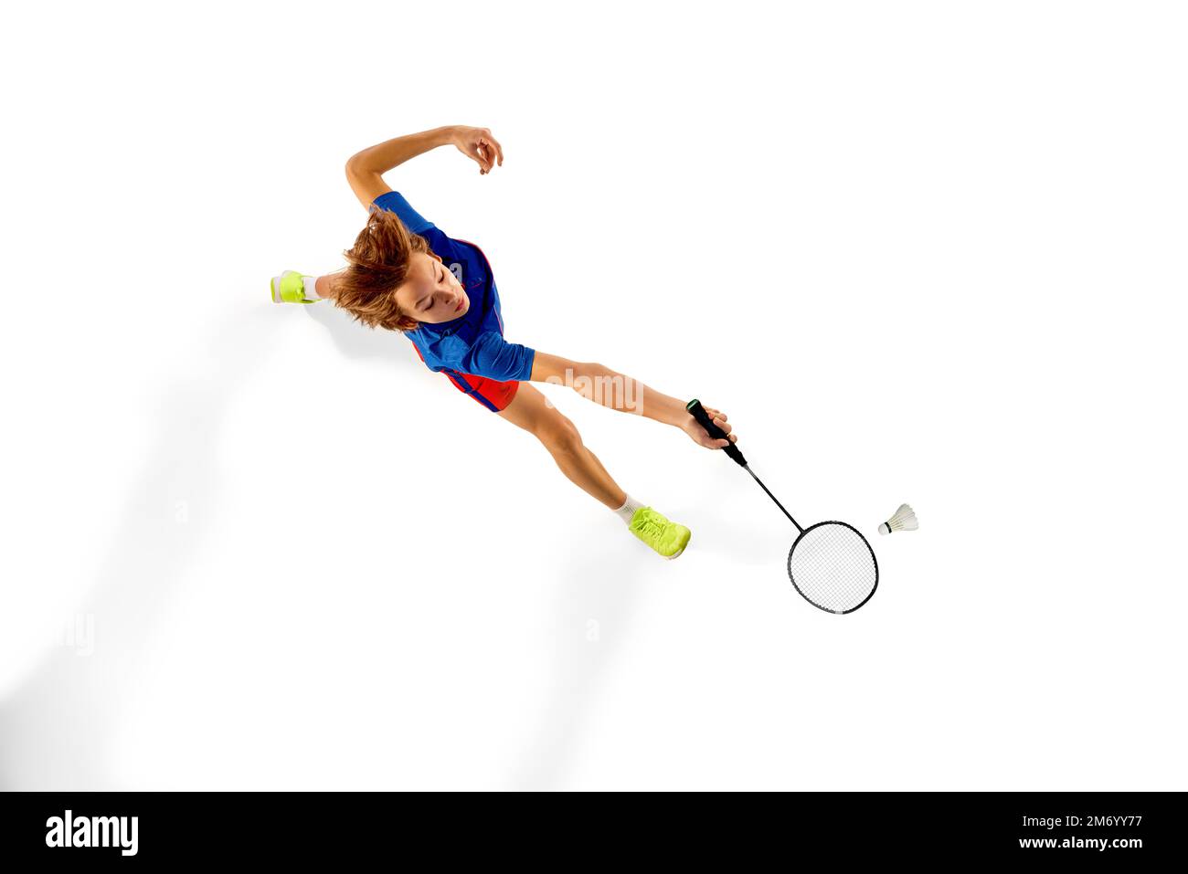 Portrait of teen boy in uniform playing badminton, serving shuttlecock ...