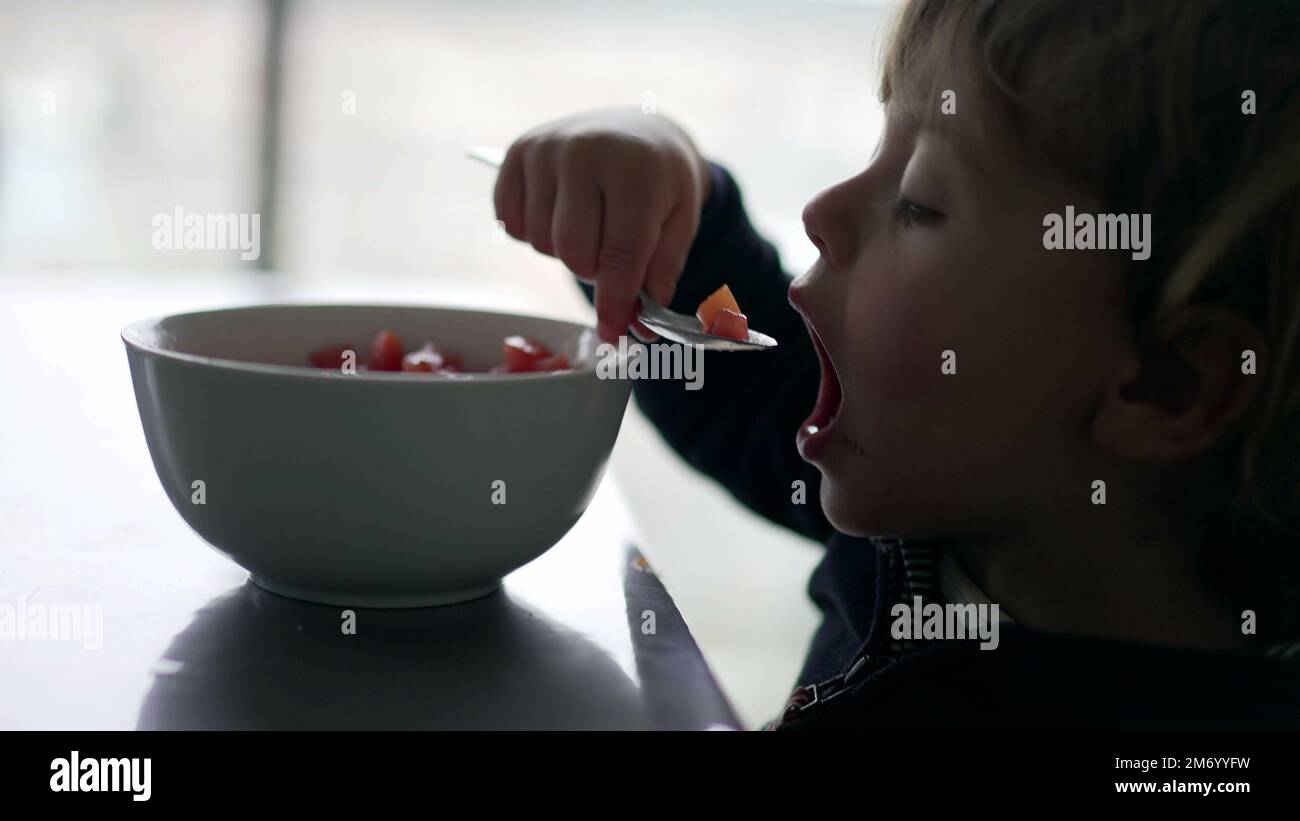 Toddler boy eating healthy bowl tomatoes2 Stock Photo - Alamy