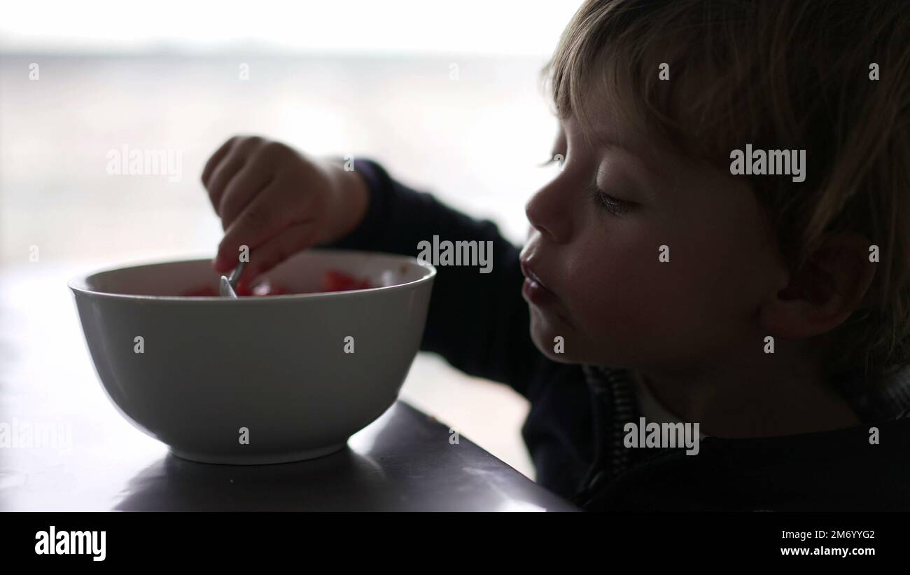 Toddler boy eating healthy bowl tomatoes3 Stock Photo - Alamy