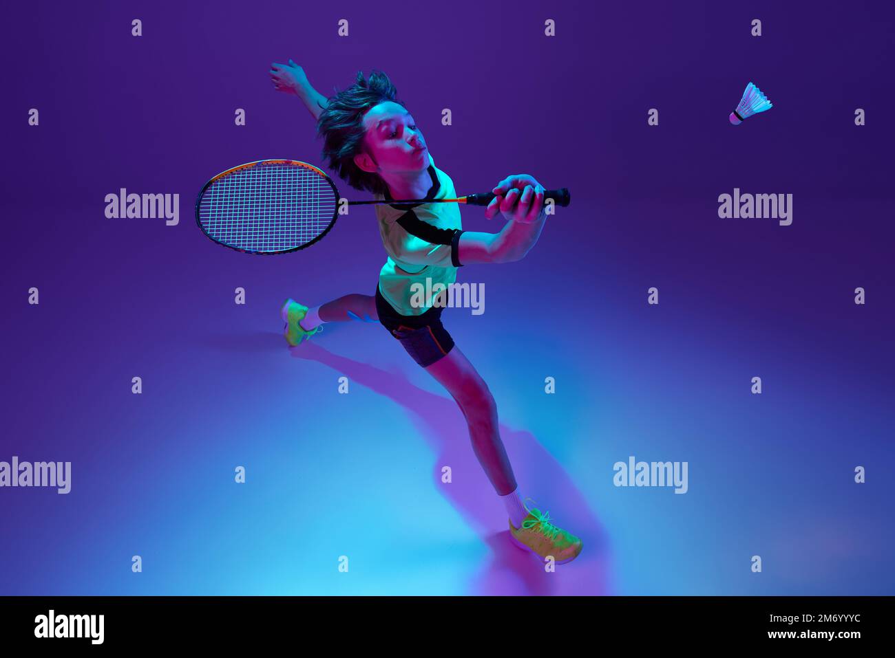Top view. Portrait of teen boy in uniform playing badminton, returning ...