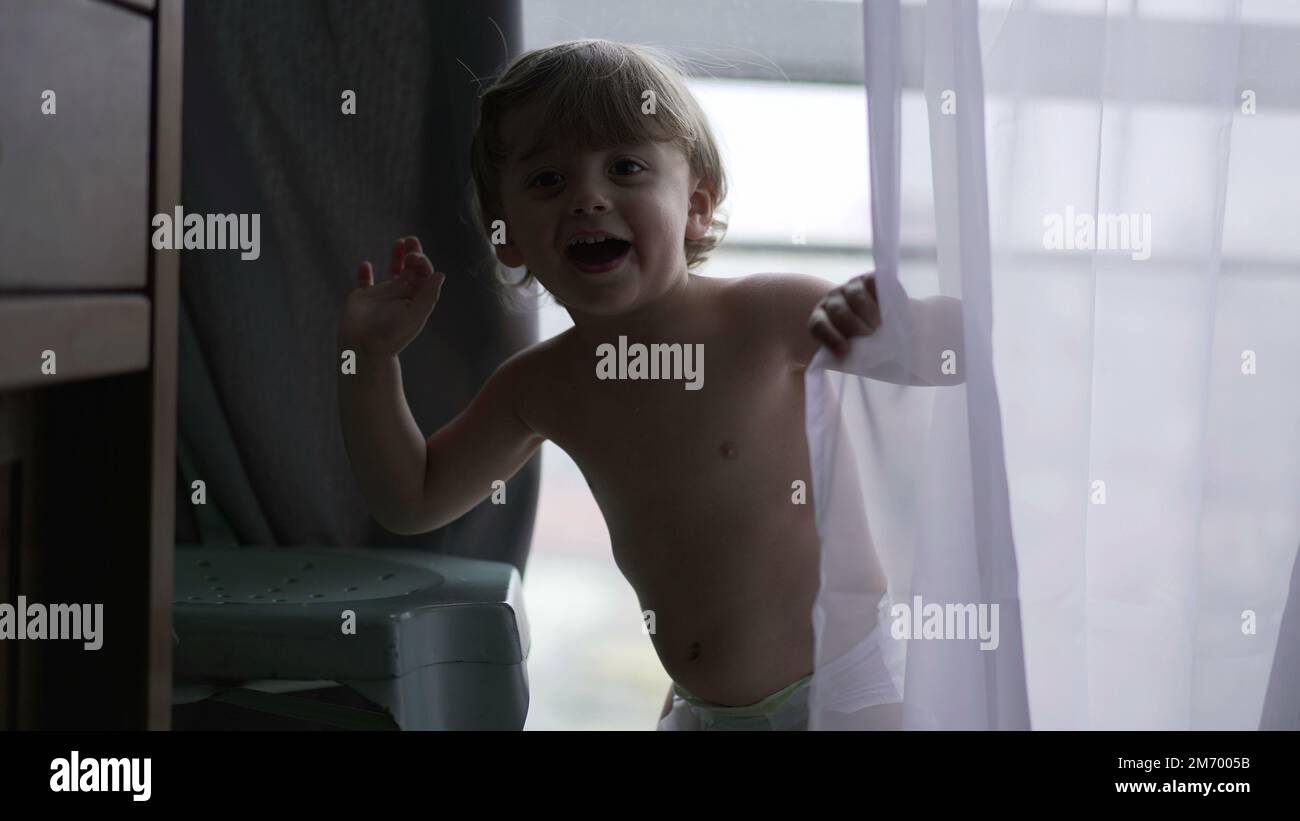Toddler boy hitting chair with arm and hand standing smiling Stock ...