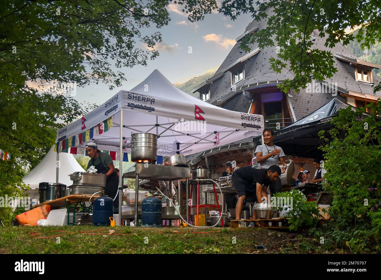 Young men cooking typical Nepalese food in a field kitchen in the ...