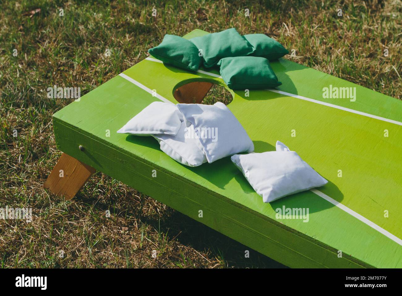 Green and white cornhole board and bean bags activity for backyard ...