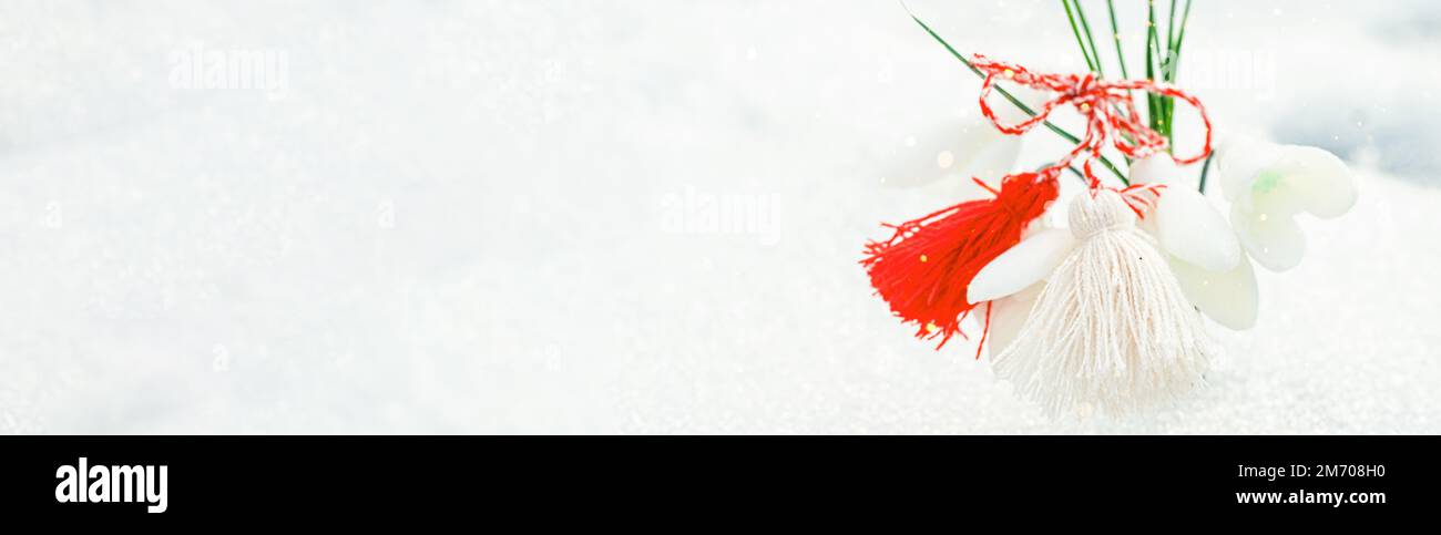 white and red cord martisor. Martenitsa in the snow in the spring ...