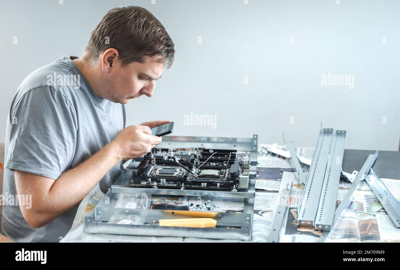 Man engineer,collector.Independent self computer assembly. Mounting in ... Man engineer,collector.Independent self computer assembly. Mounting in ...
