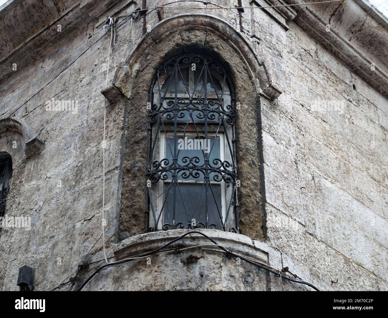 corner window with a forged decorative grille on an old building in ...
