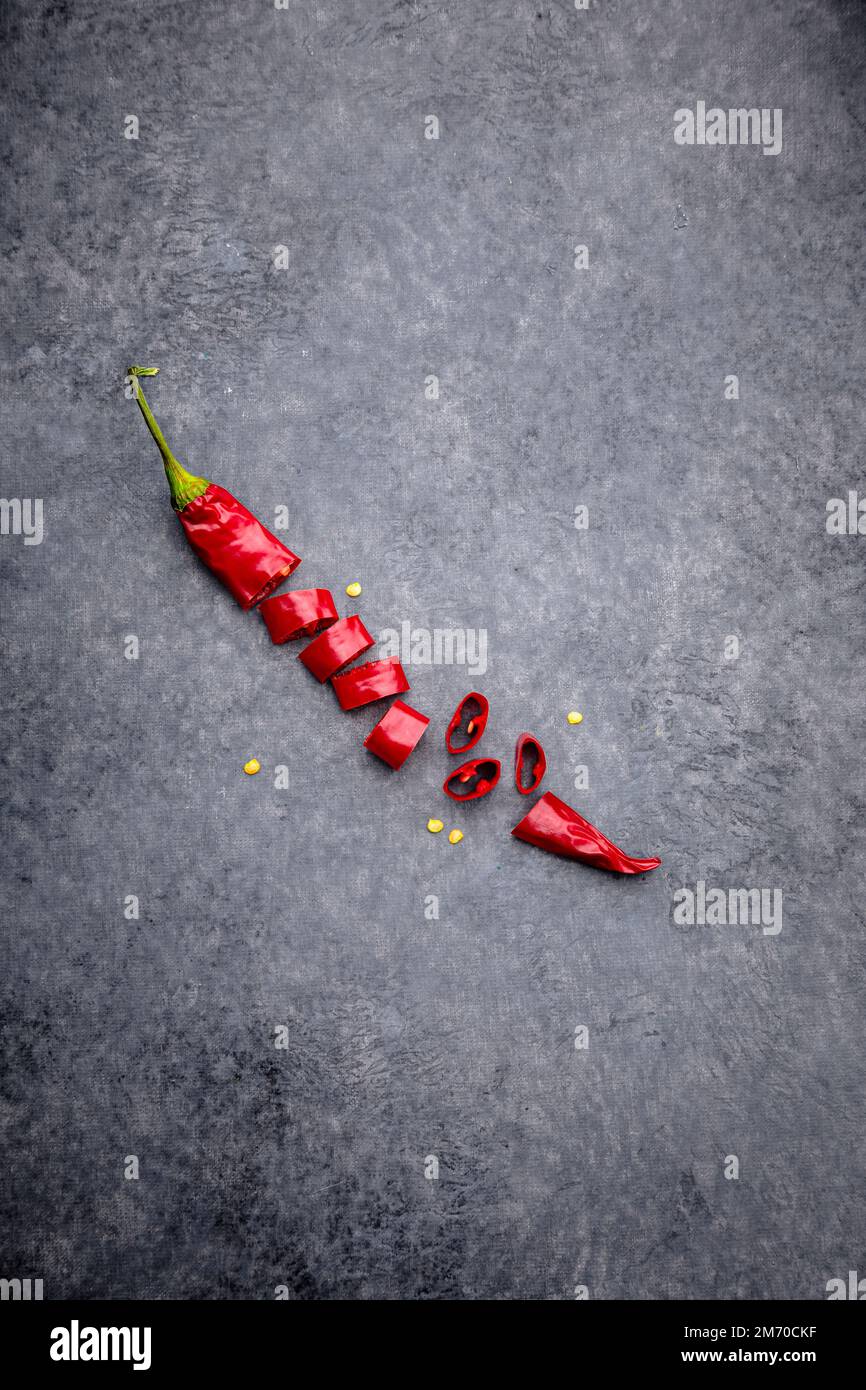 Cut chilli pepper over gray background Stock Photo - Alamy