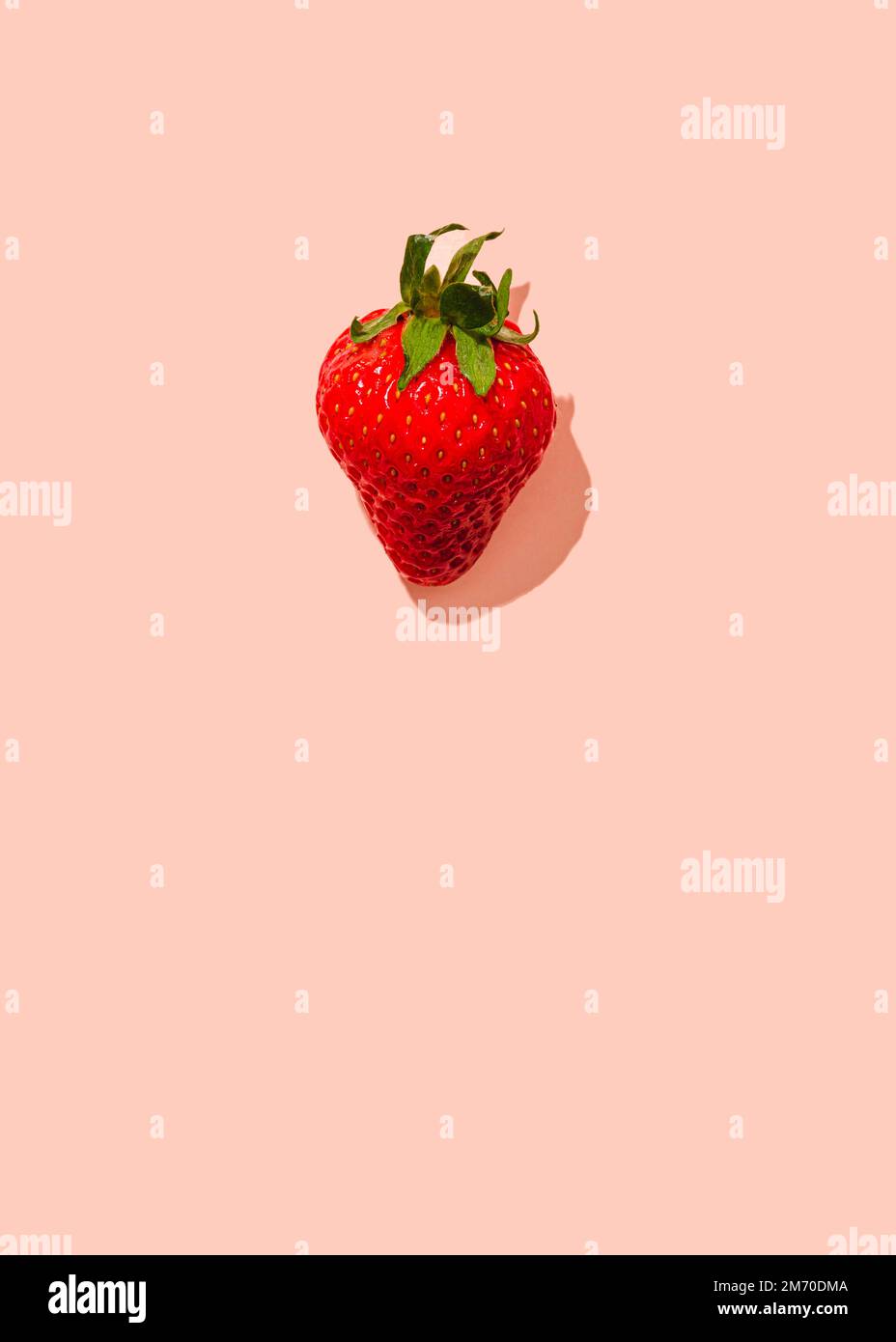 Single strawberry on pink background Stock Photo - Alamy