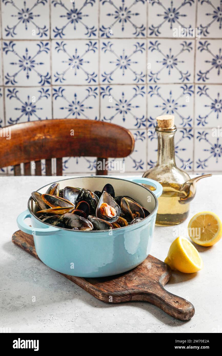mussels in white wine and lemon juice in a blue cast-iron caseroll ...