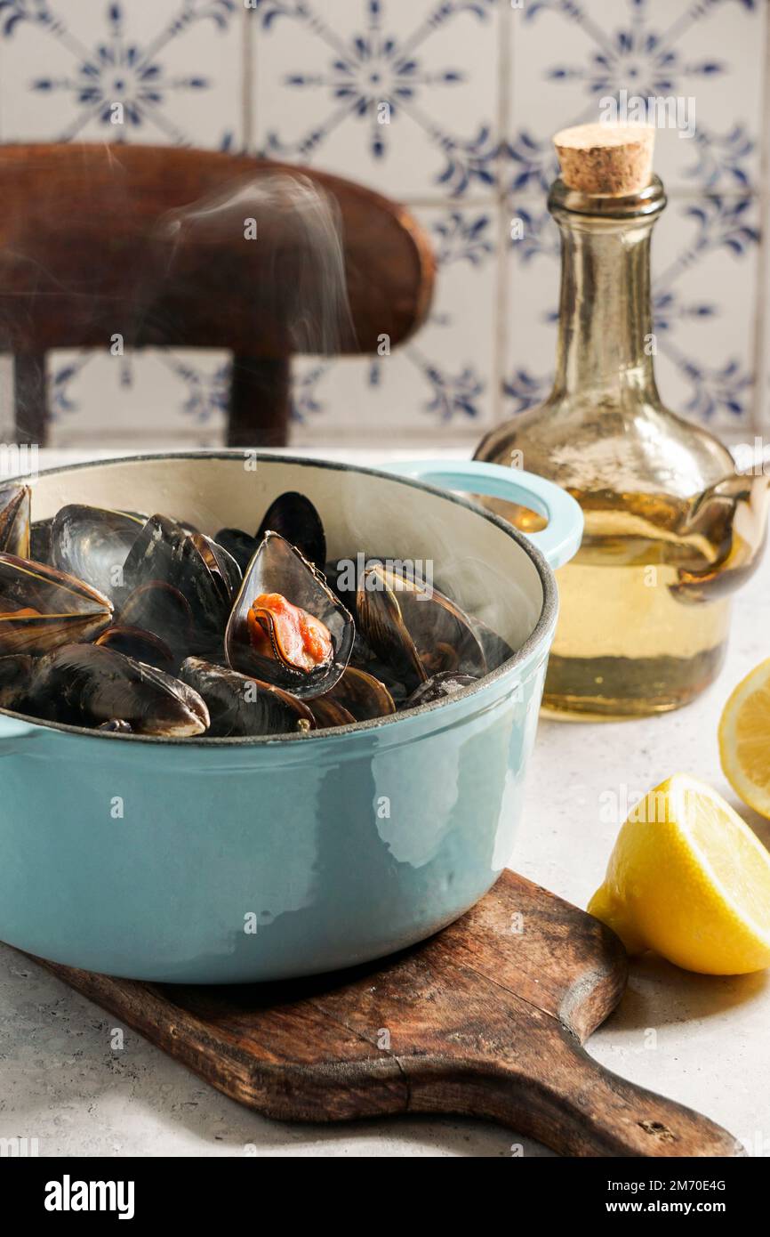 mussels in white wine and lemon juice in a blue cast-iron caseroll ...