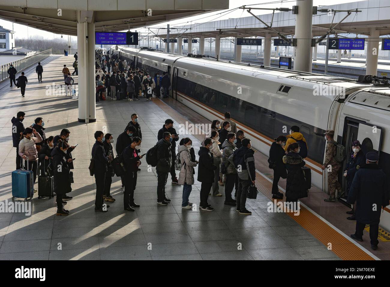 Passengers line up to enter the bullet train at the high speed rail ...