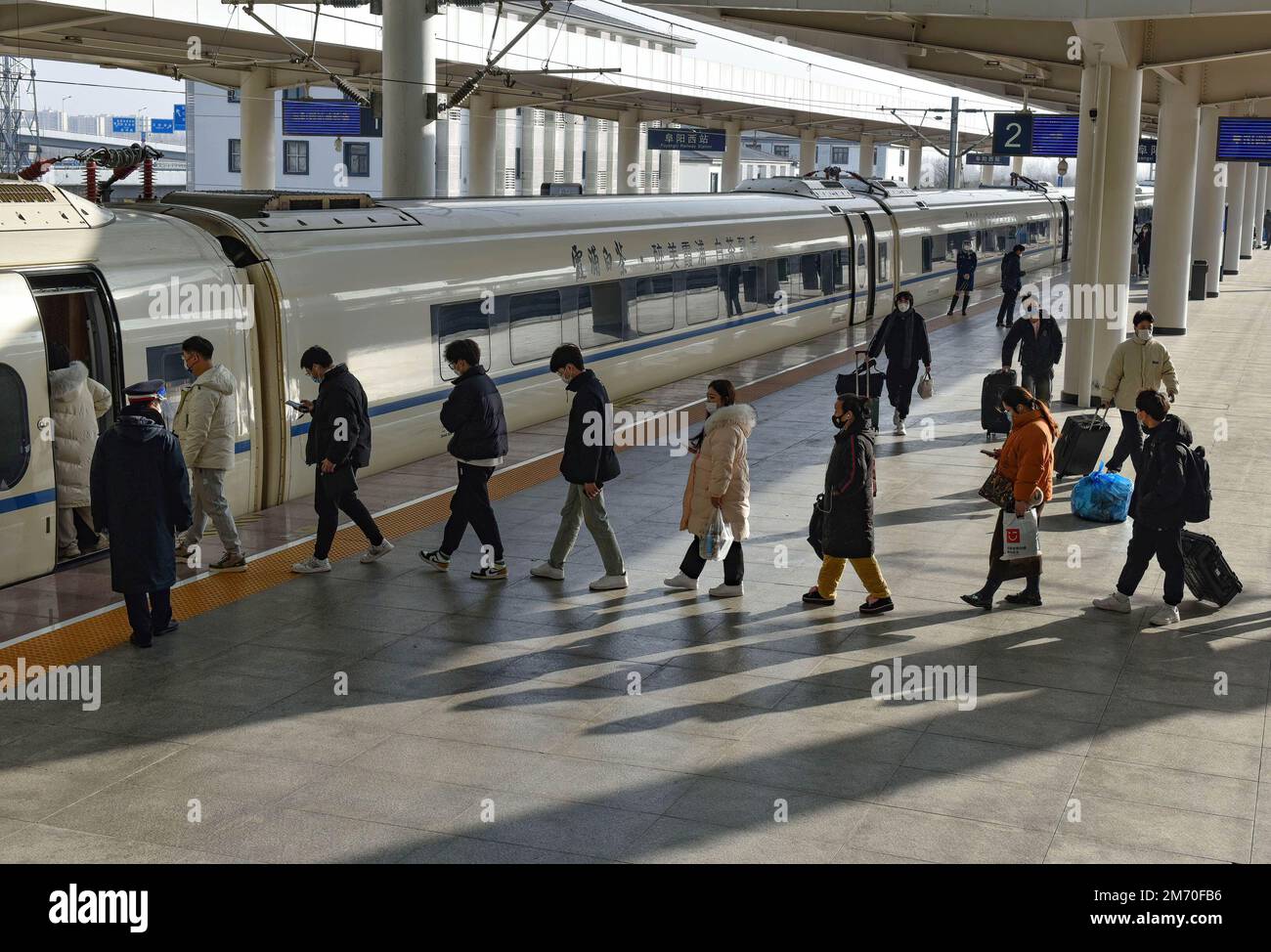 Passengers line up to enter the bullet train at the high speed rail ...