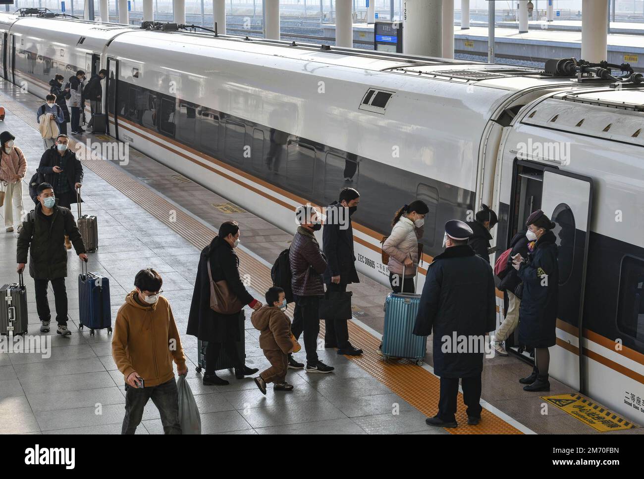 Passengers line up to enter the bullet train at the high speed rail ...