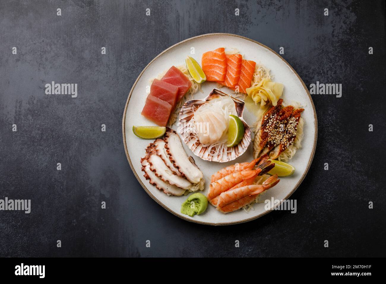 Sashimi sushi set with scallop on shell with daikon and lemon on plate ...