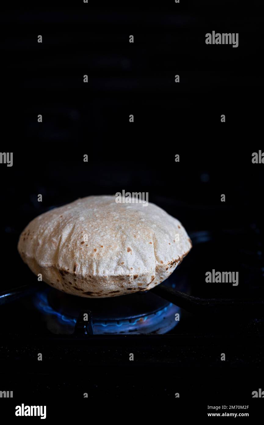 Phulka roti cooked on the flame Stock Photo - Alamy