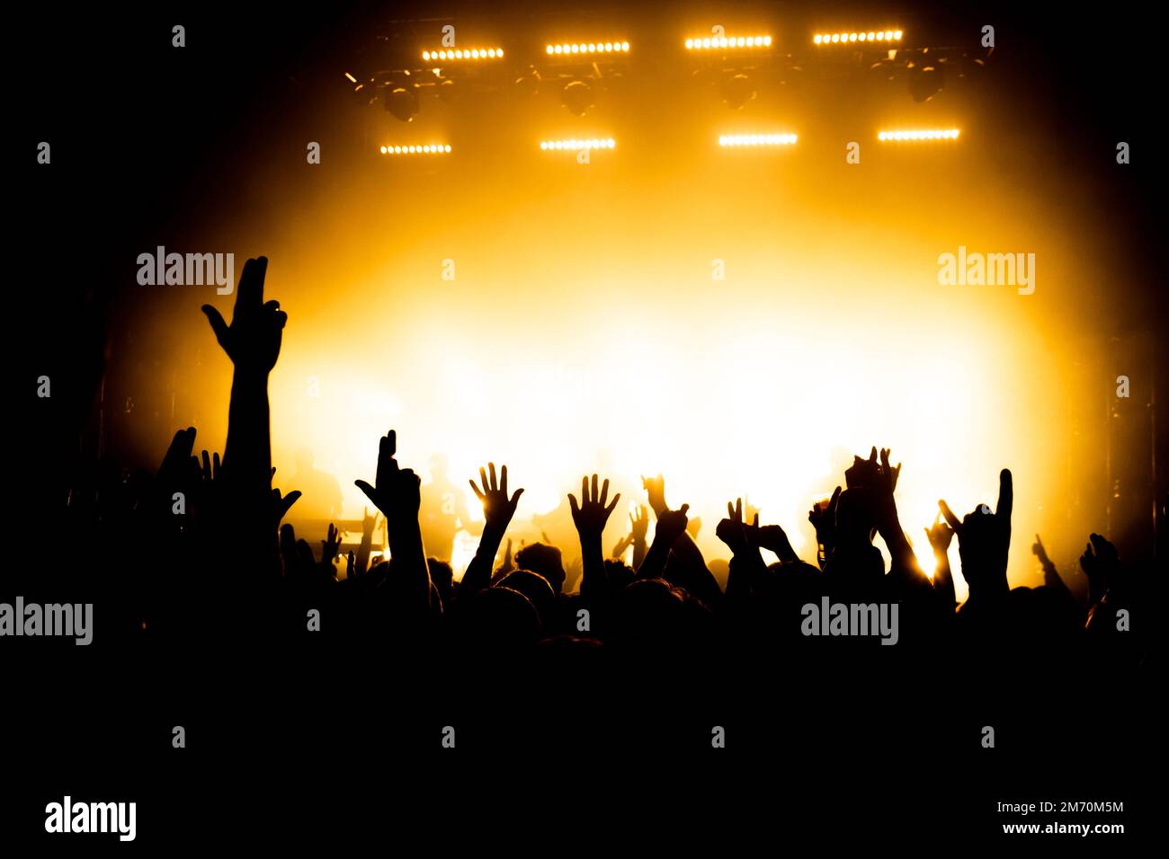 Party people wave their hands from side to side at a live concert at ...