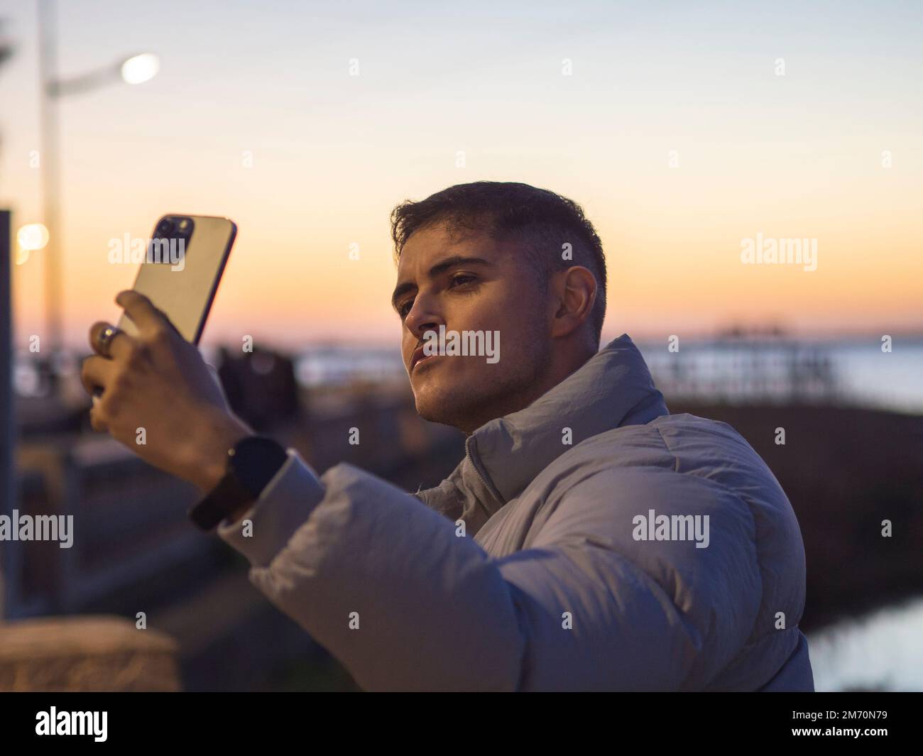 A closeup of a handsome male taking a photo in the evening while ...