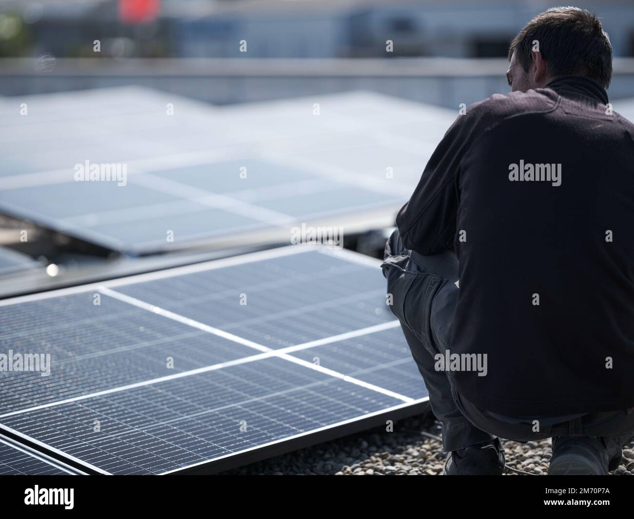 Male team engineers installing stand-alone solar photovoltaic panel ...