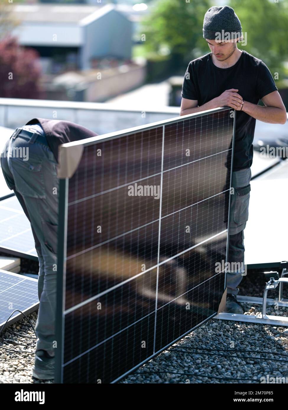 Male team engineers installing stand-alone solar photovoltaic panel ...