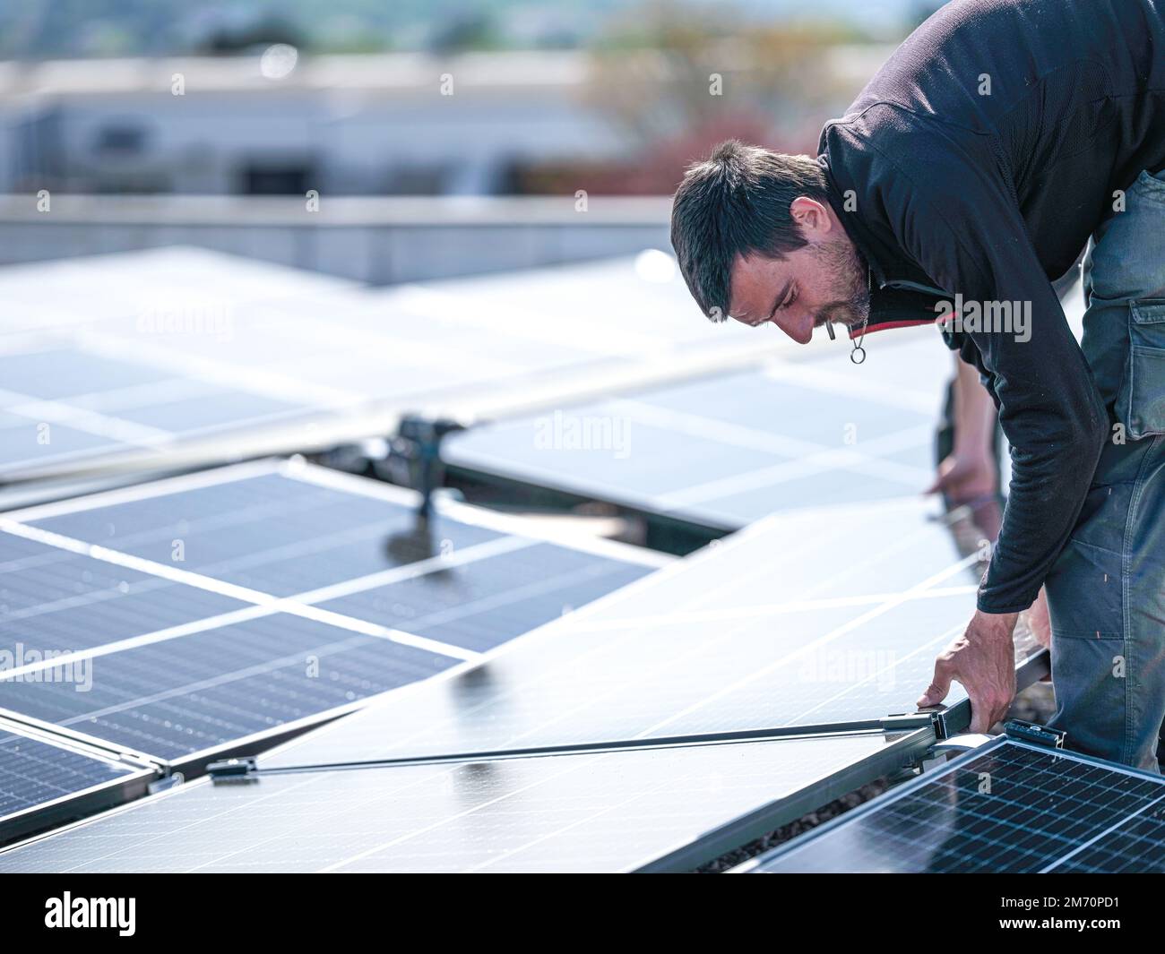 Male team engineers installing stand-alone solar photovoltaic panel ...