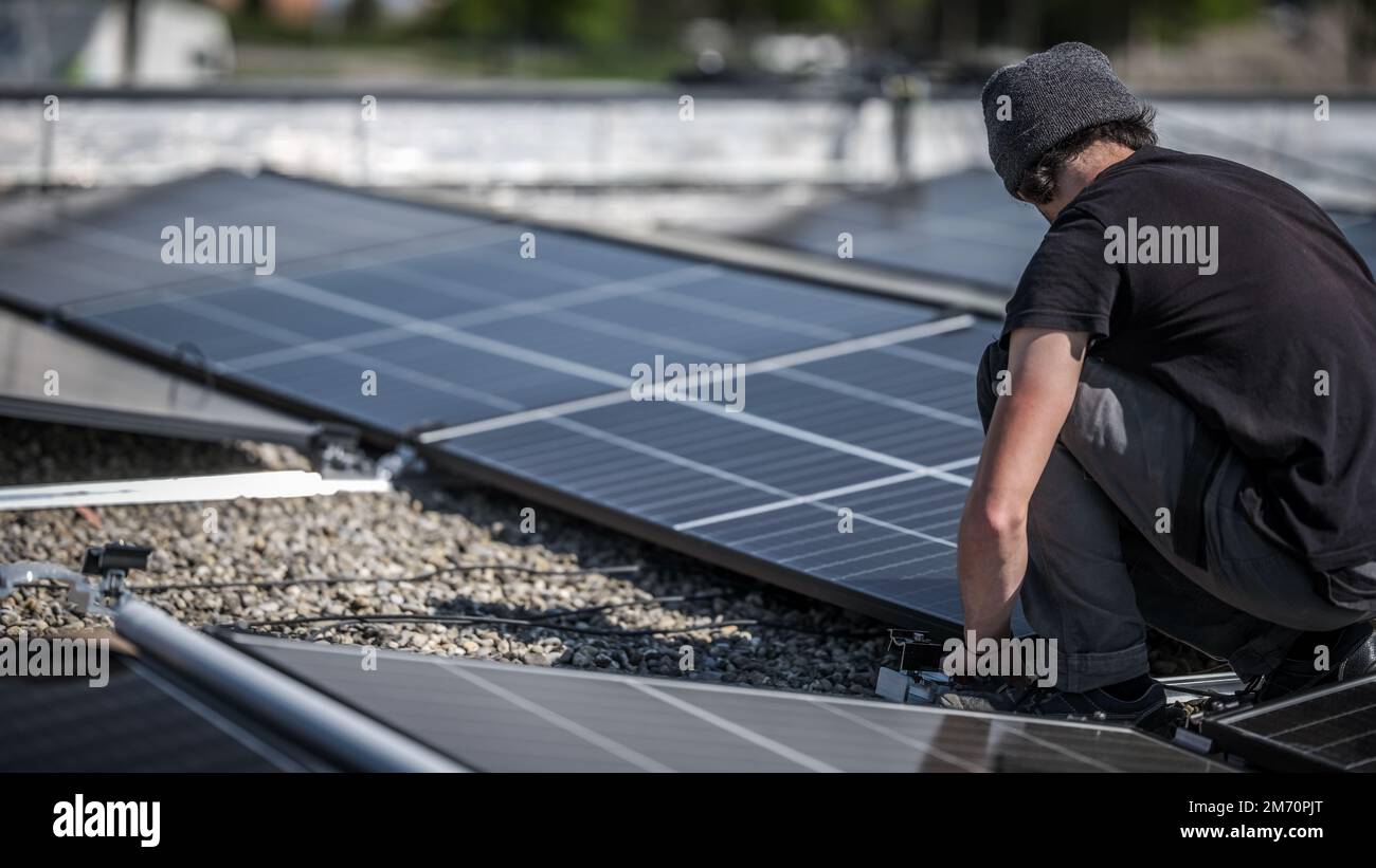 Male team engineers installing stand-alone solar photovoltaic panel ...