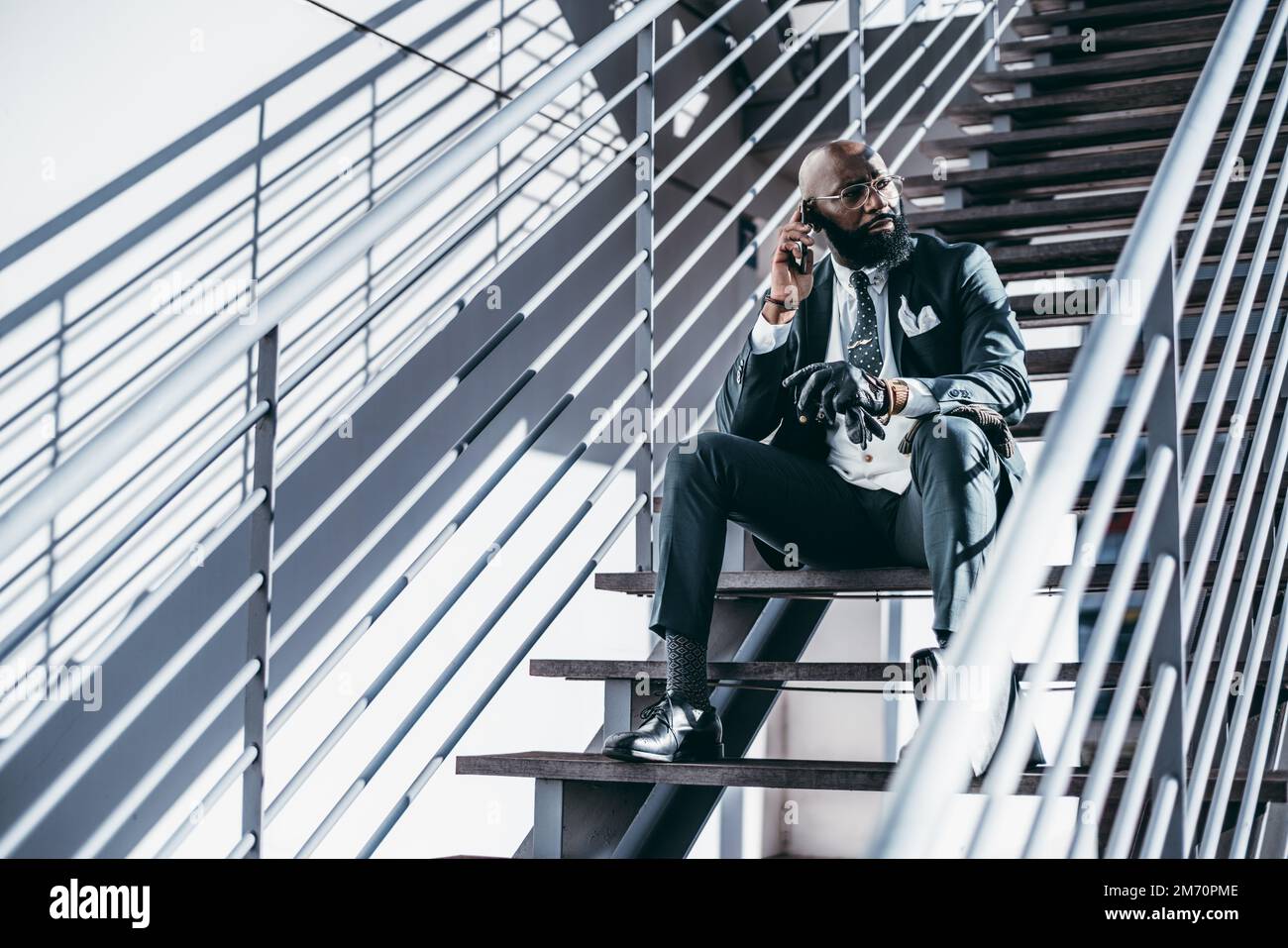 A serious fancy bald bearded black man entrepreneur in eyeglasses, a ...
